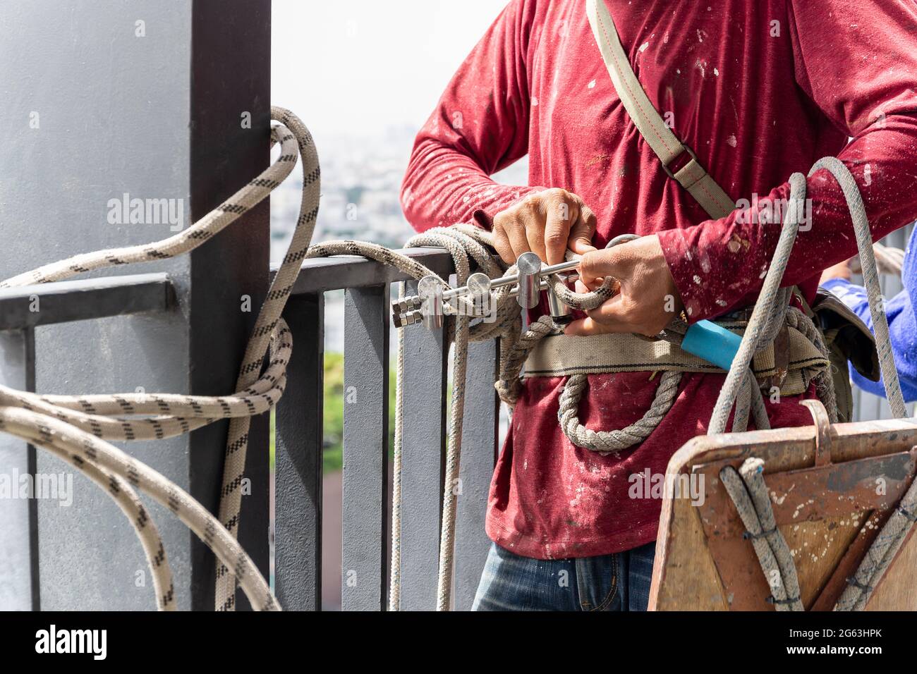 Construction workers holding steel hooks connecting with rope for self ...