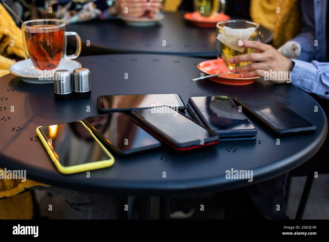 Stack of smartphones on black table at the cafe Stock Photo - Alamy