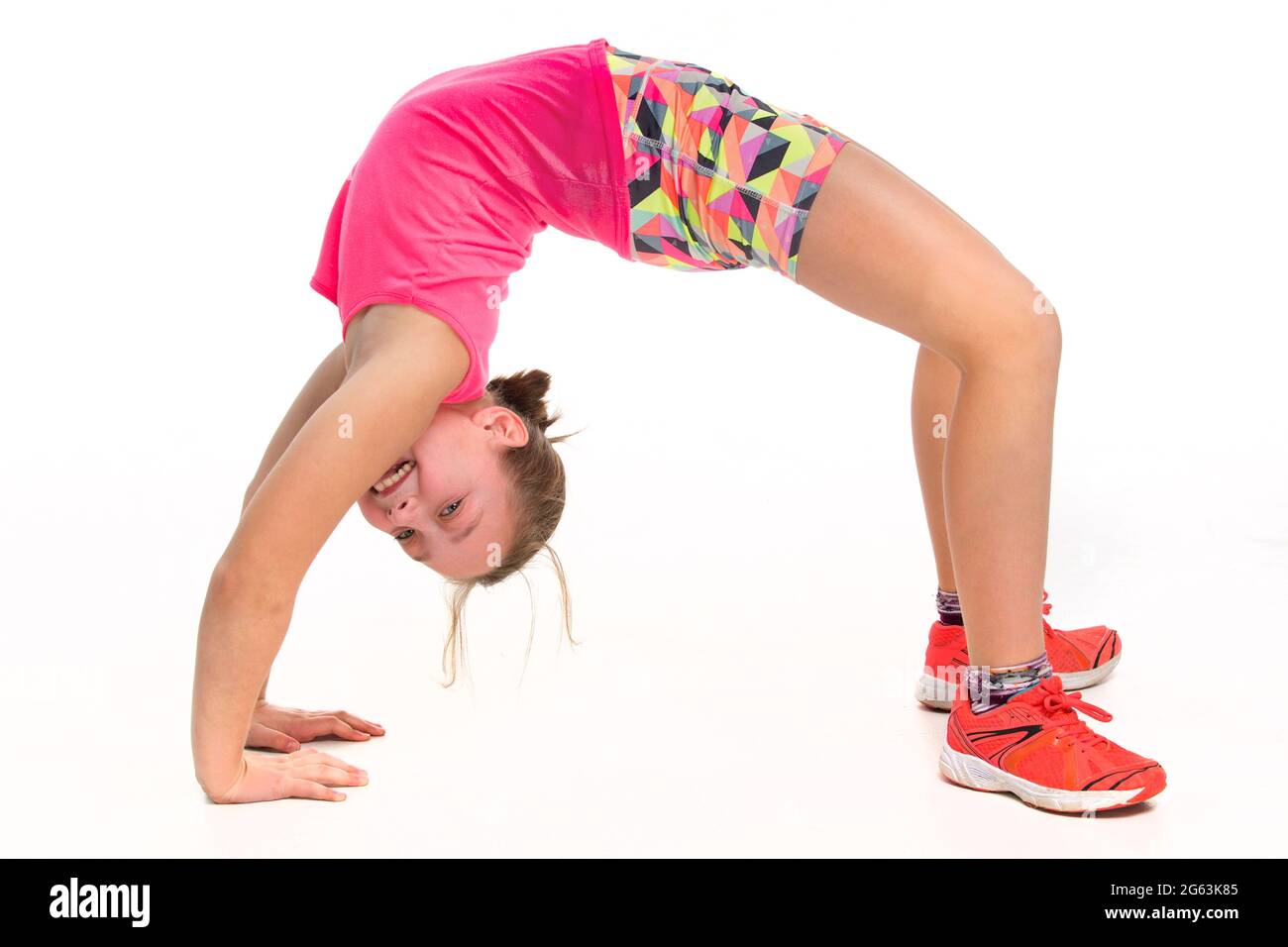 Girl doing a backward stretch while smiling to camera Stock Photo - Alamy