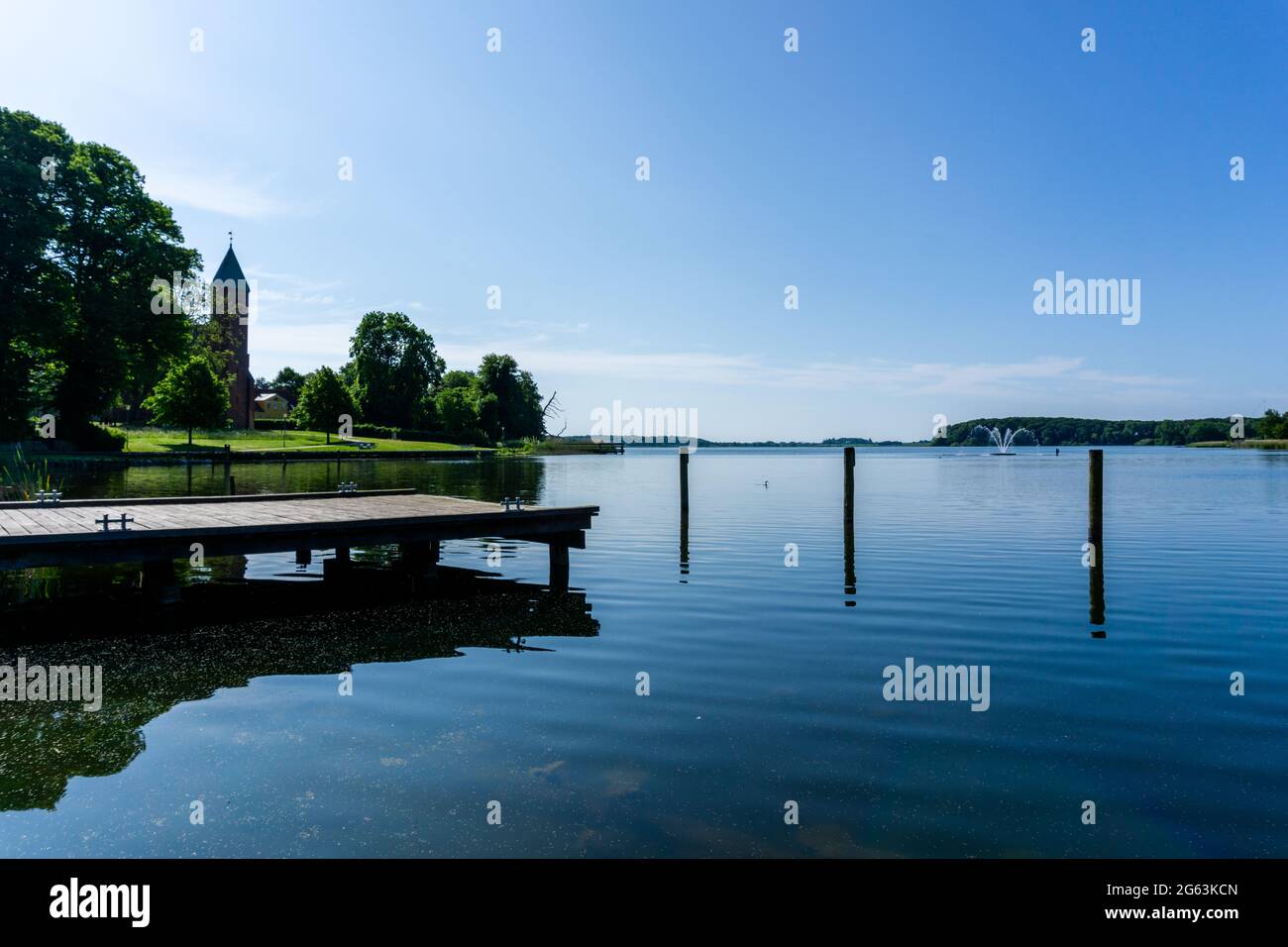 A view of the Maribo Cathedral and Maribo Lake with a wooden dock in ...