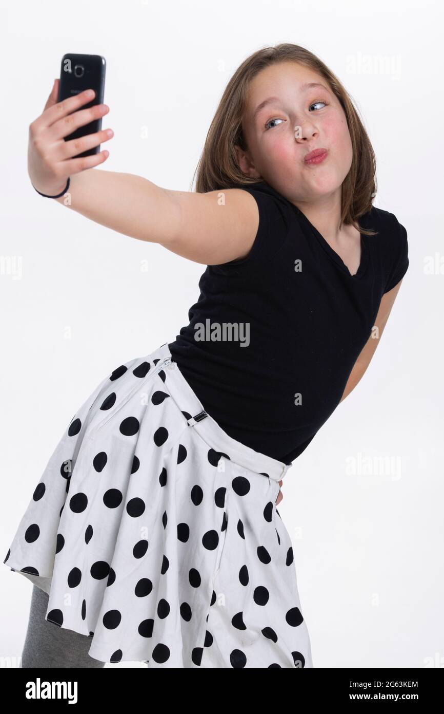 A young tween pouting for a self potrait on her phone Stock Photo - Alamy