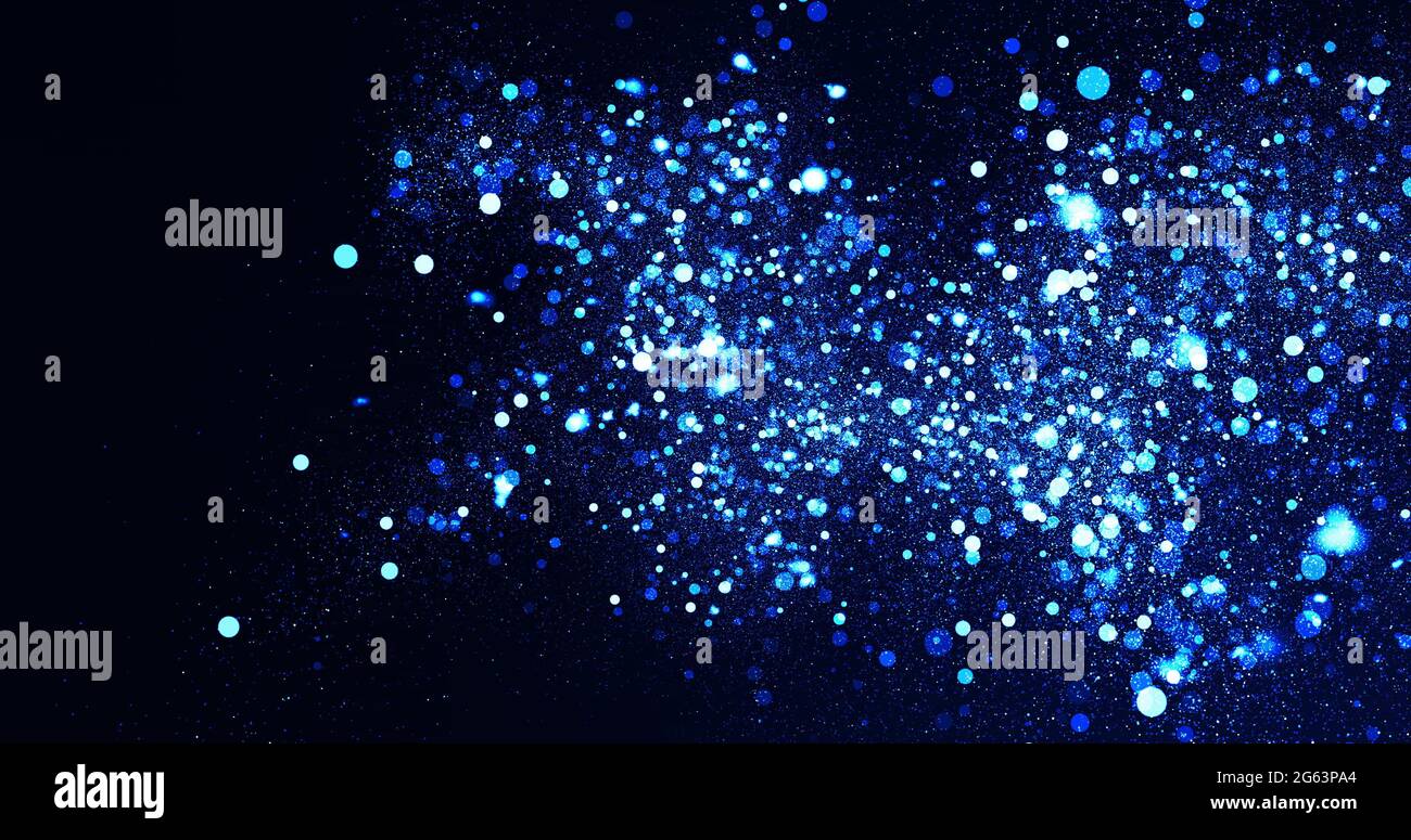 Illuminated blue and white particles floating on a black background ...