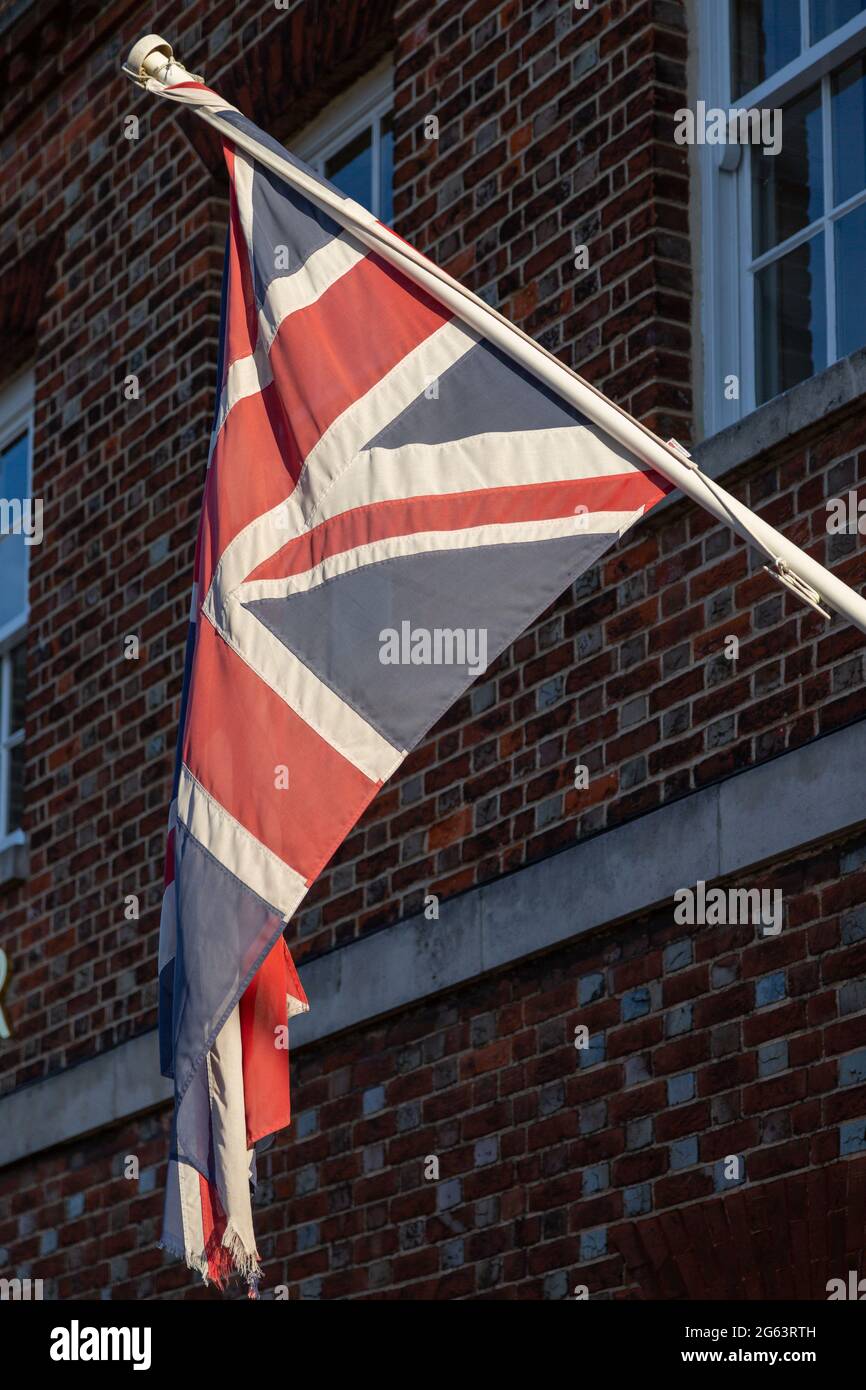 A union jack flag flying outside a brick building Stock Photo - Alamy