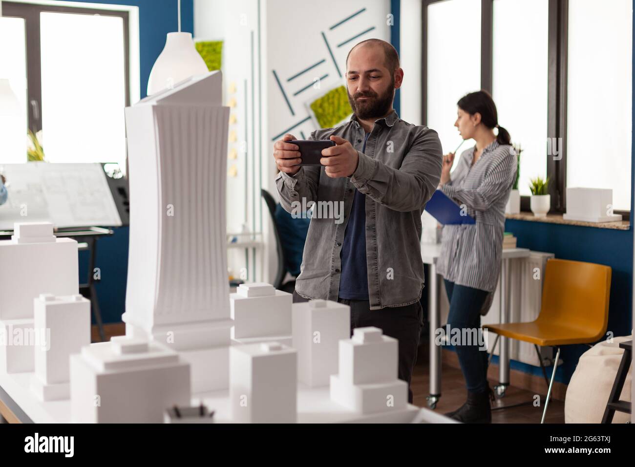 Design constructor looking at smartphone for project of architectural ...