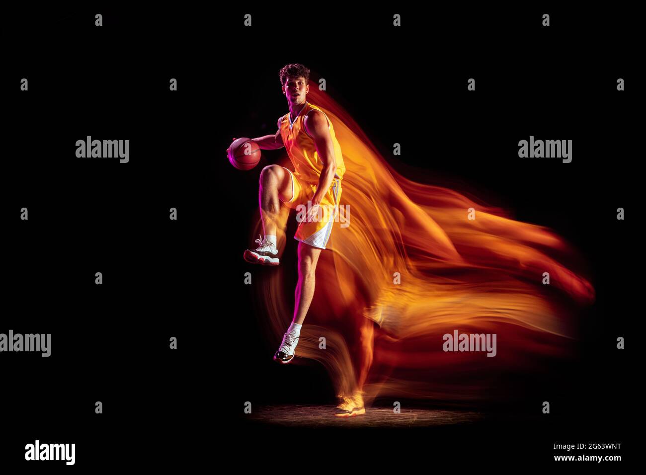 Young Caucasian basketball player training isolated on black background ...