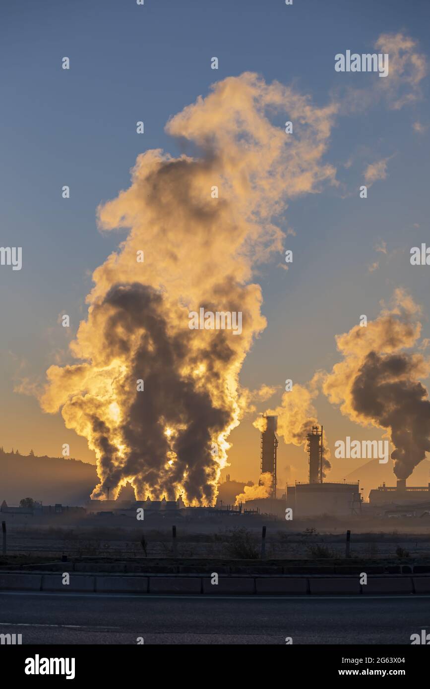 Huge smoke coming out from the chemical factory and spreading in a blue ...