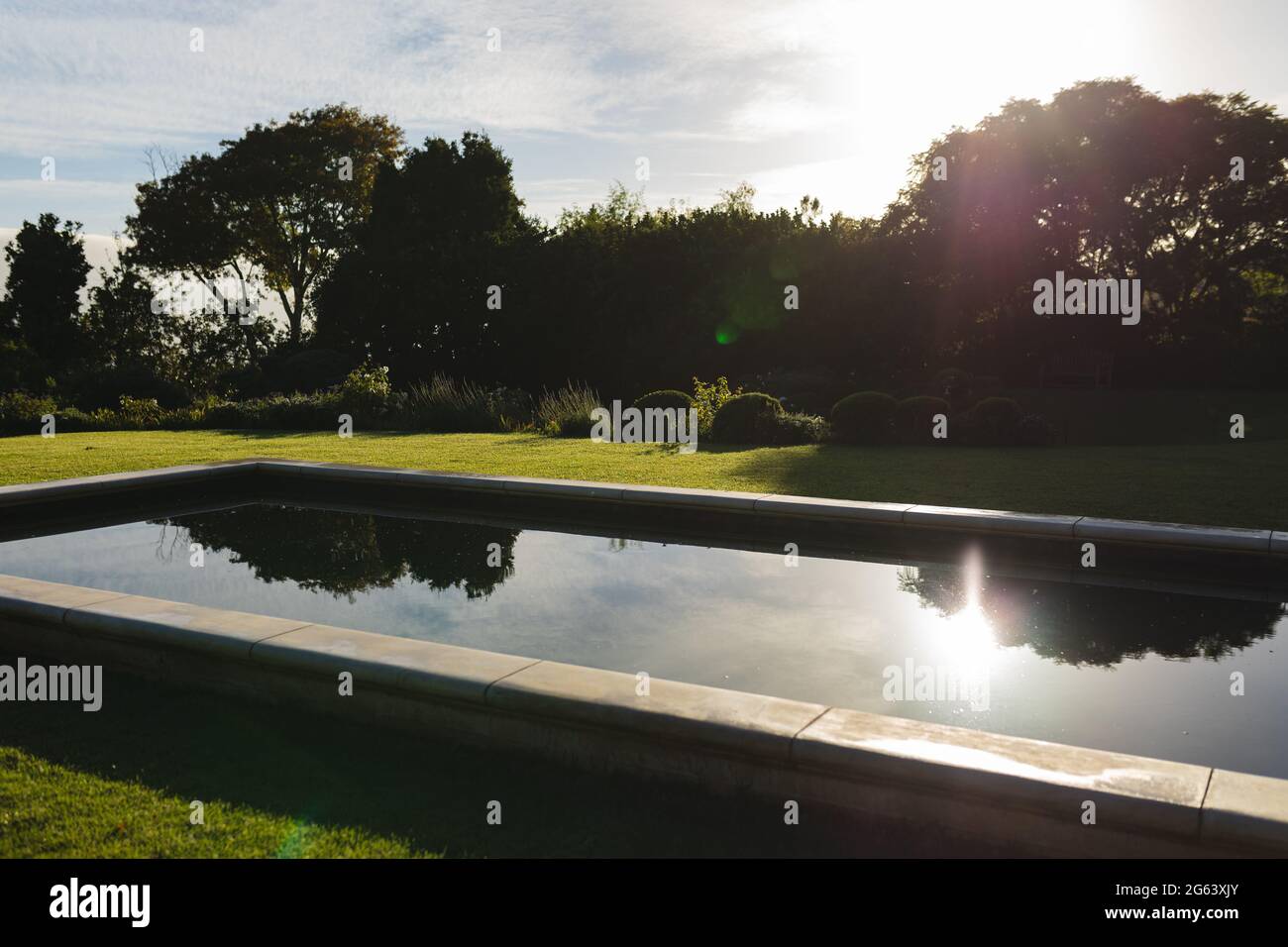 General view of tranquil swimming pool in stunning sunny countryside ...