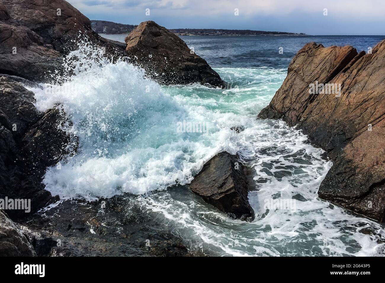 The ocean water splashing off the rocks in Rockport, Massachusetts ...