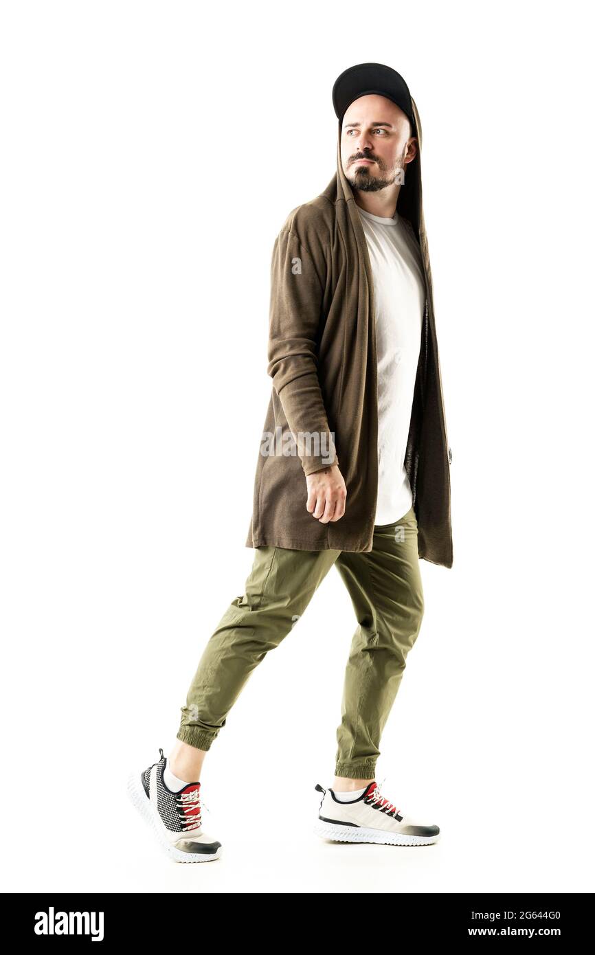 Side view of stylish trendy man with cap and hooded cardigan walking ...