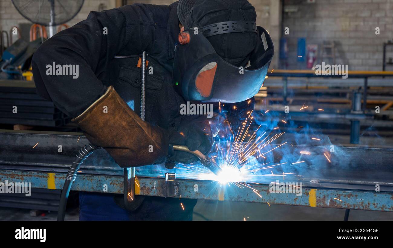 Worker welding in steel workshop with bright light and sparks Stock ...