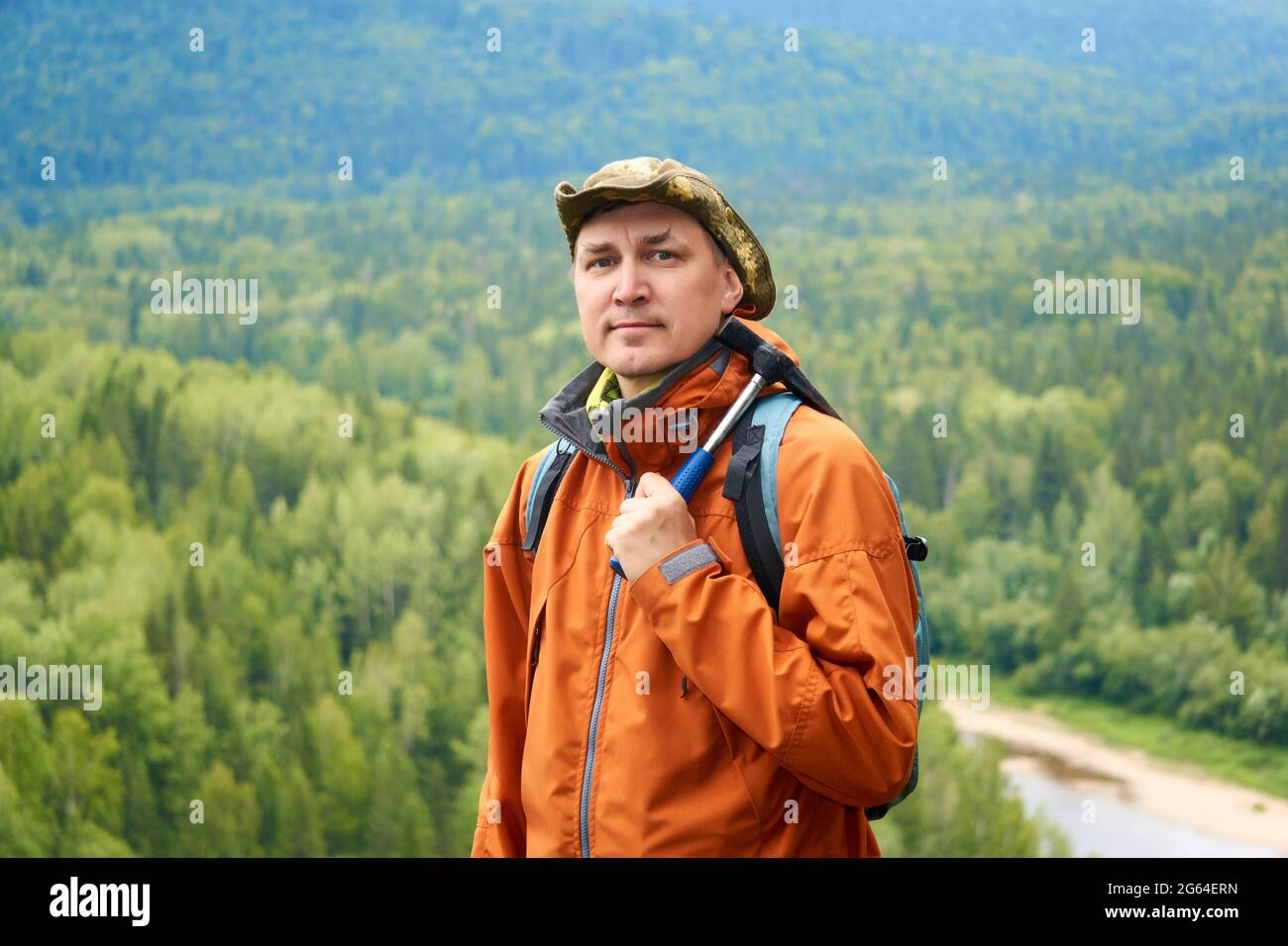 portrait of a man geologist with a backpack and a geological hammer in ...