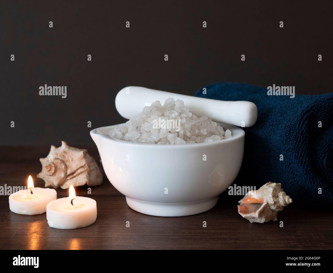 Spa composition with bowl filled with sea salt, towel, burning candles ...