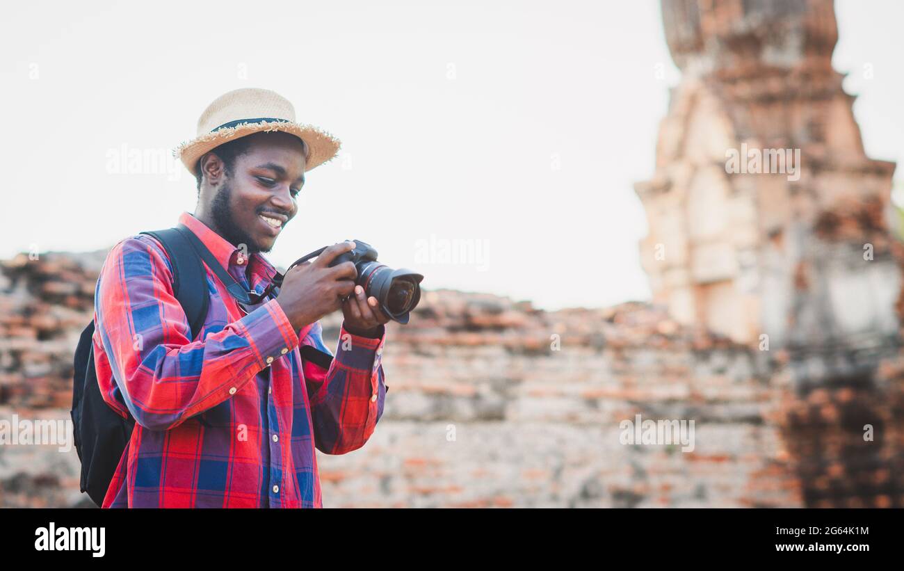African male photographer enjoying to taking and looking pictures of ...