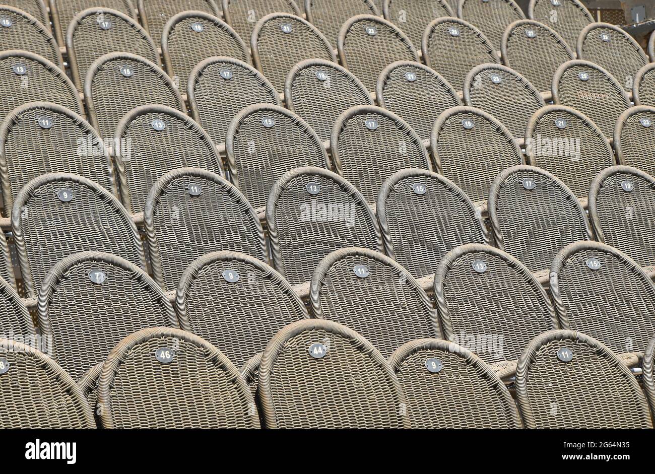 Rows of empty grey brown wicker seats in open air concert hall ...