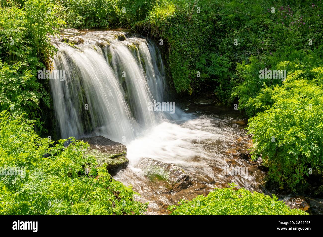Long exposure of a waterfall flowing onto Lee Abbey Beach in Devon ...