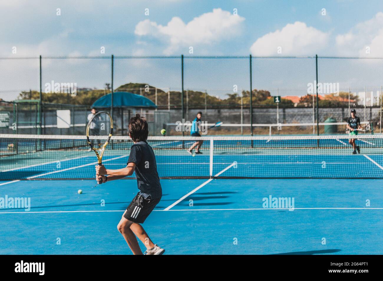 Back view of a junior boy playing tennis Stock Photo - Alamy