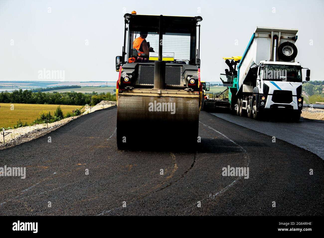 Repair of roads. Laying asphalt with a roller Stock Photo - Alamy