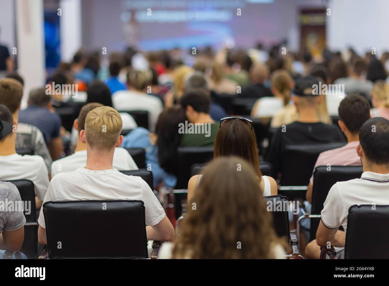 Speaker on the podium. People at conference hall, rear view Stock Photo ...