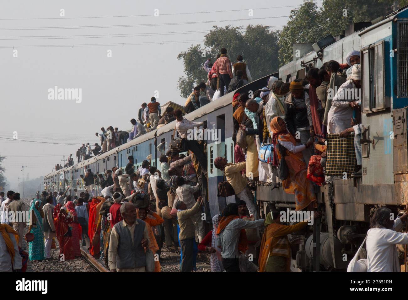 Indian train, with people hanging off it Stock Photo - Alamy