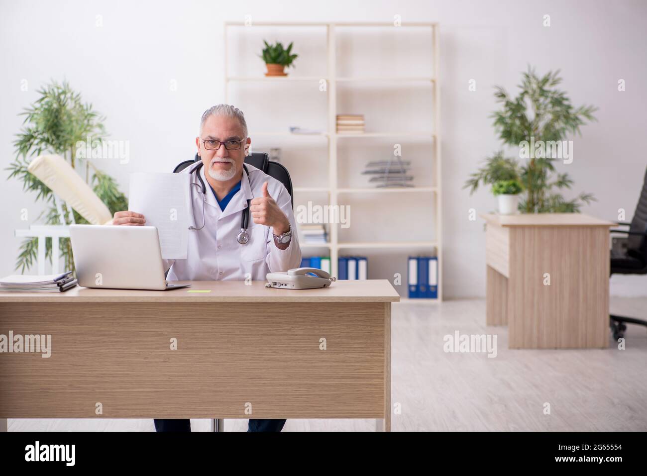Old doctor working in the clinic Stock Photo - Alamy
