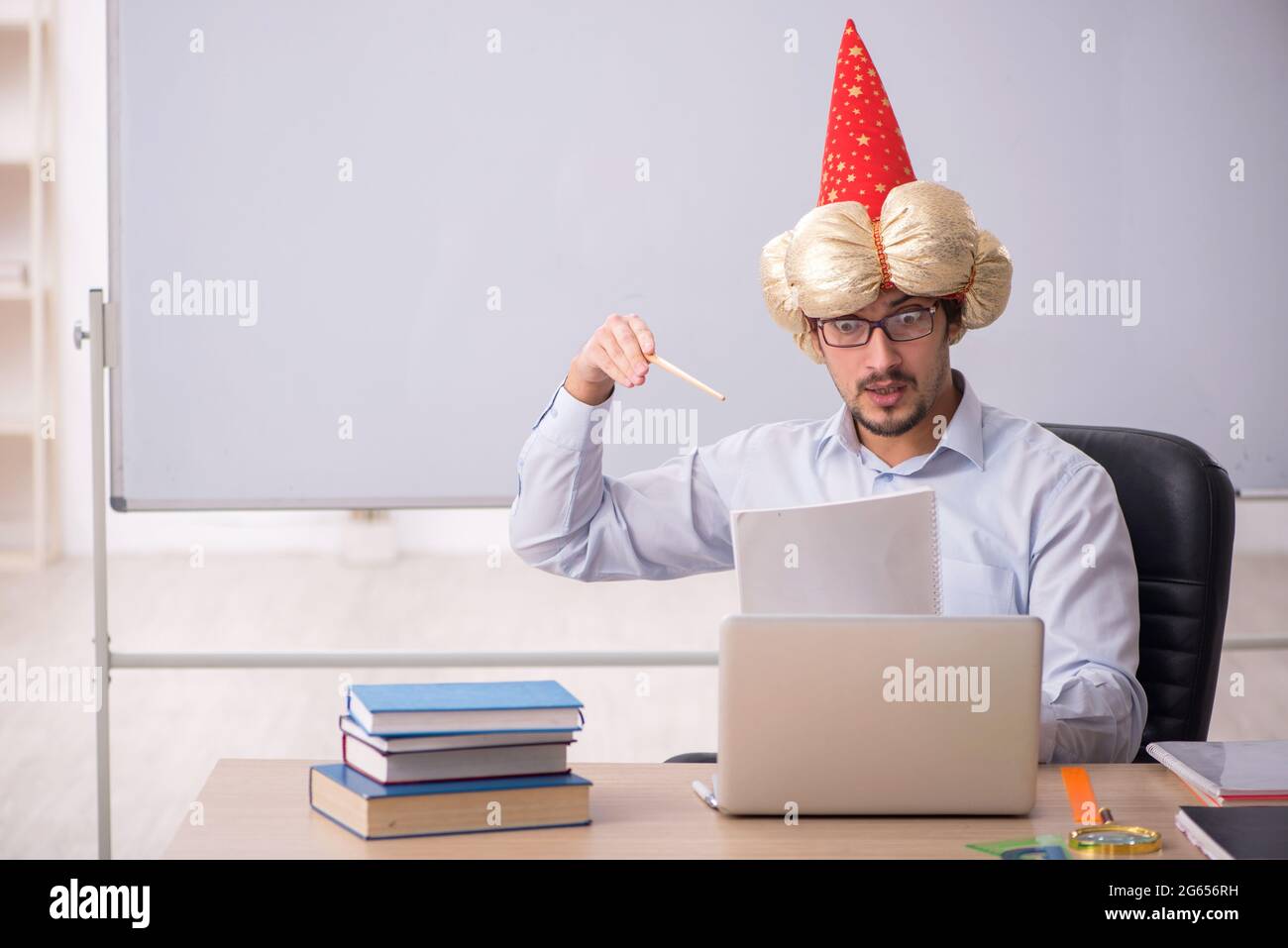 Funny young teacher magician in the classroom Stock Photo - Alamy