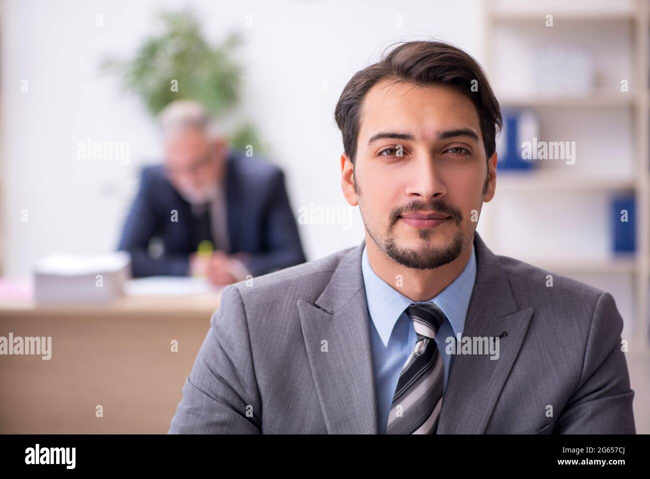 Two male employees working at workplace Stock Photo - Alamy