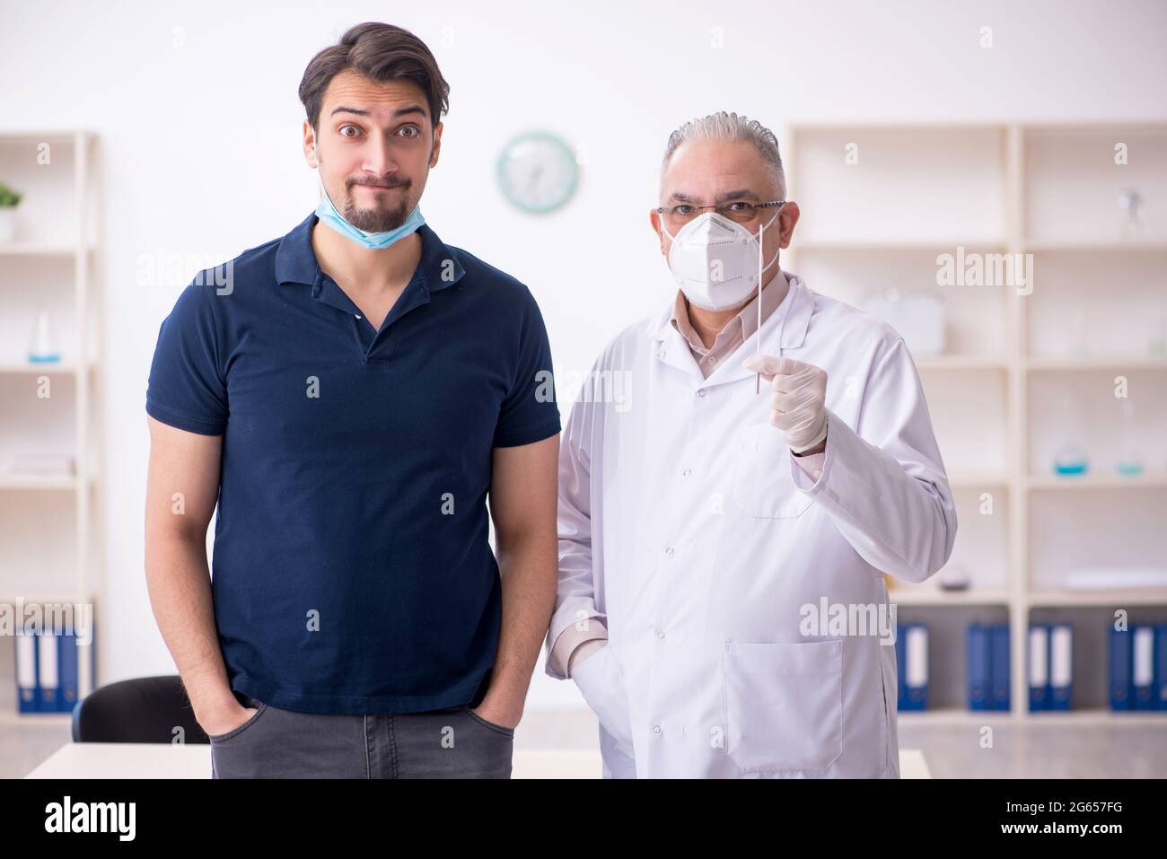 Young patient visiting old male doctor during pandemic Stock Photo - Alamy
