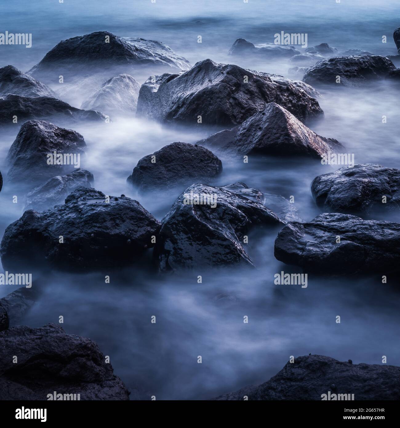 Rocks and flowing waves Stock Photo - Alamy