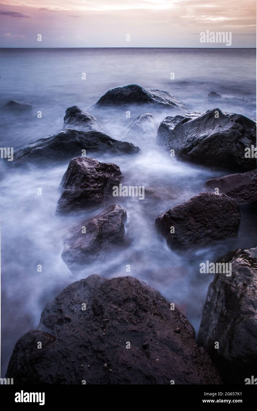 Rocks and flowing waves Stock Photo - Alamy