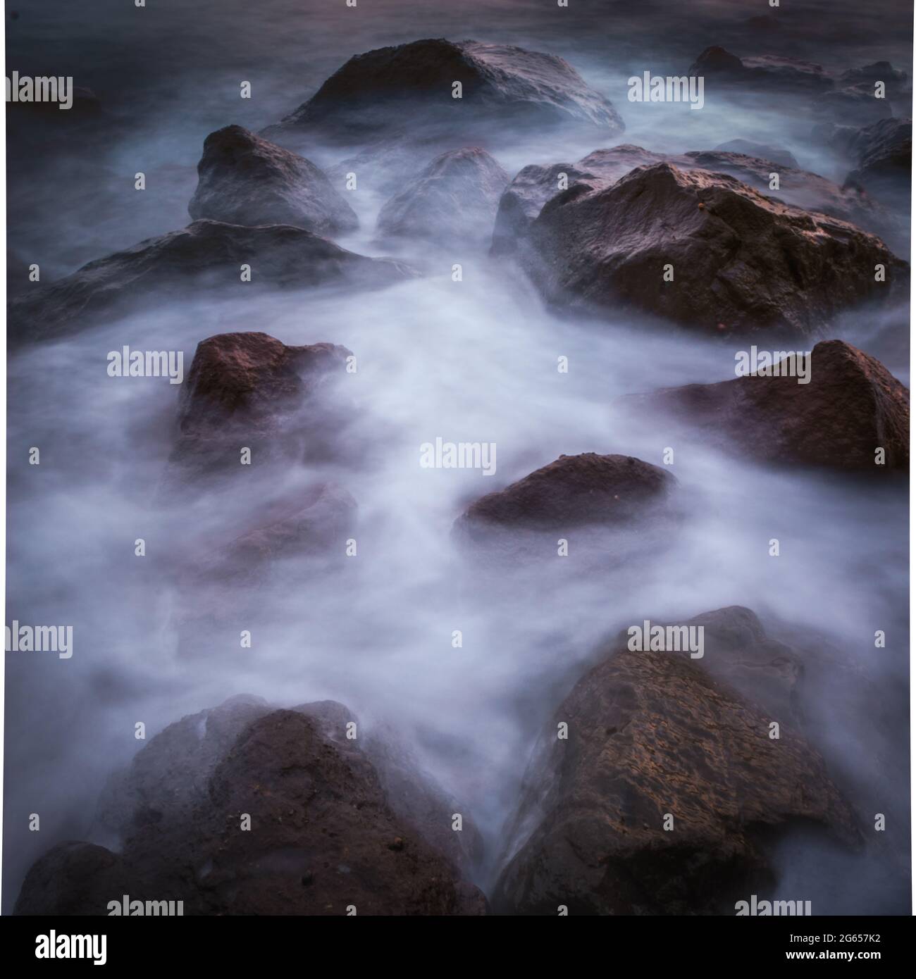 Rocks and flowing waves Stock Photo - Alamy