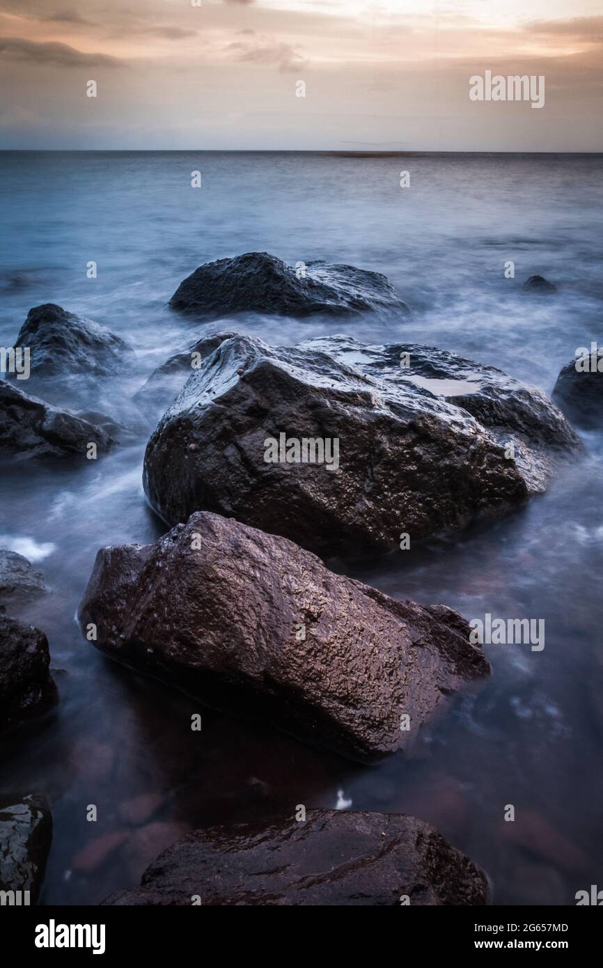 Rocks and flowing waves Stock Photo - Alamy