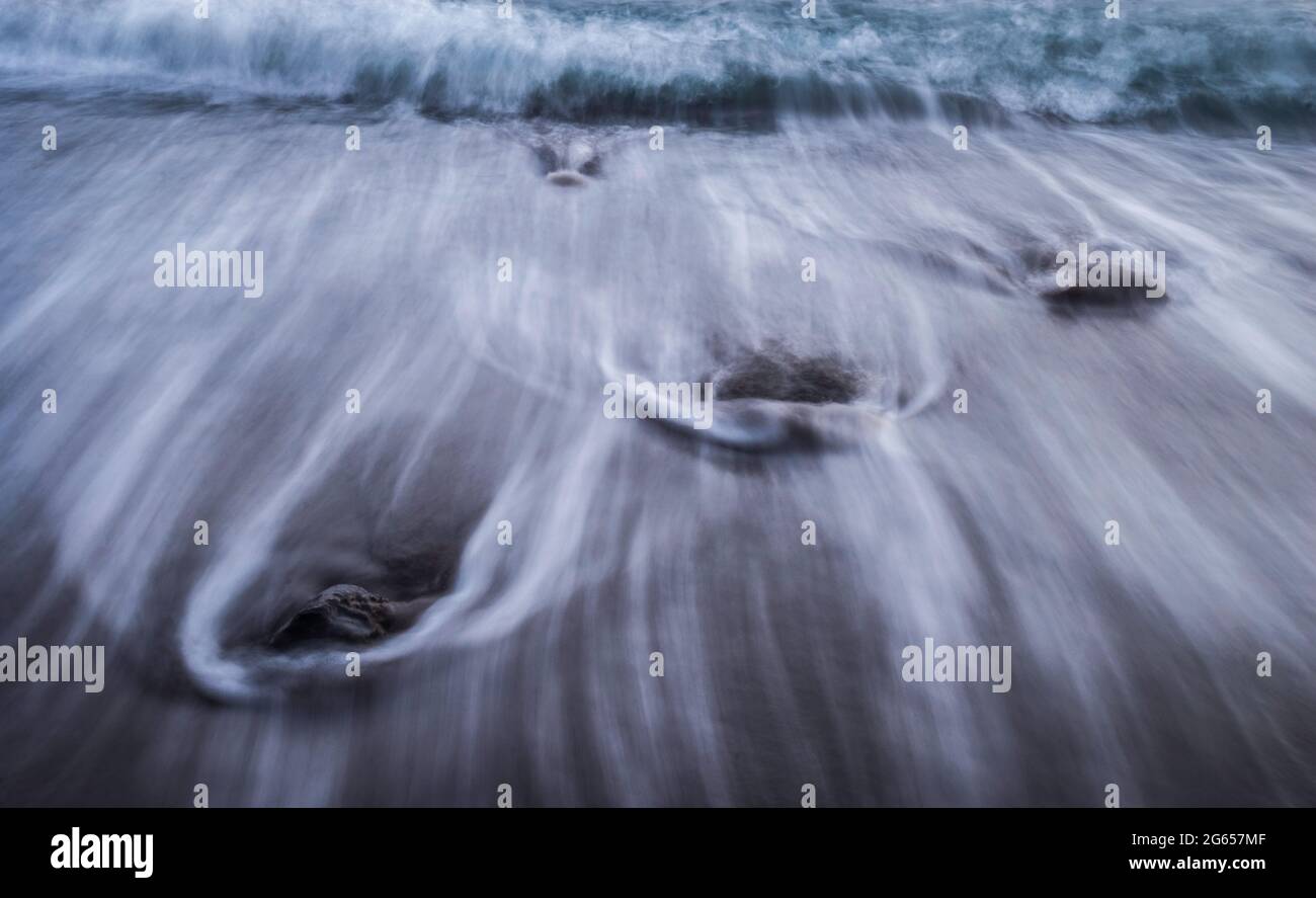 Rocks and flowing waves Stock Photo - Alamy