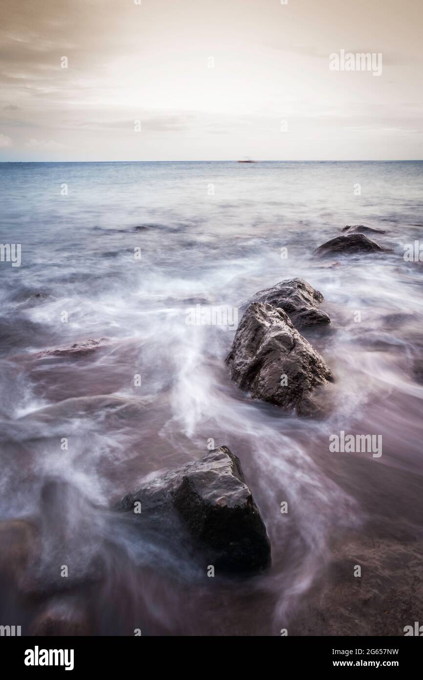Rocks and flowing waves Stock Photo - Alamy
