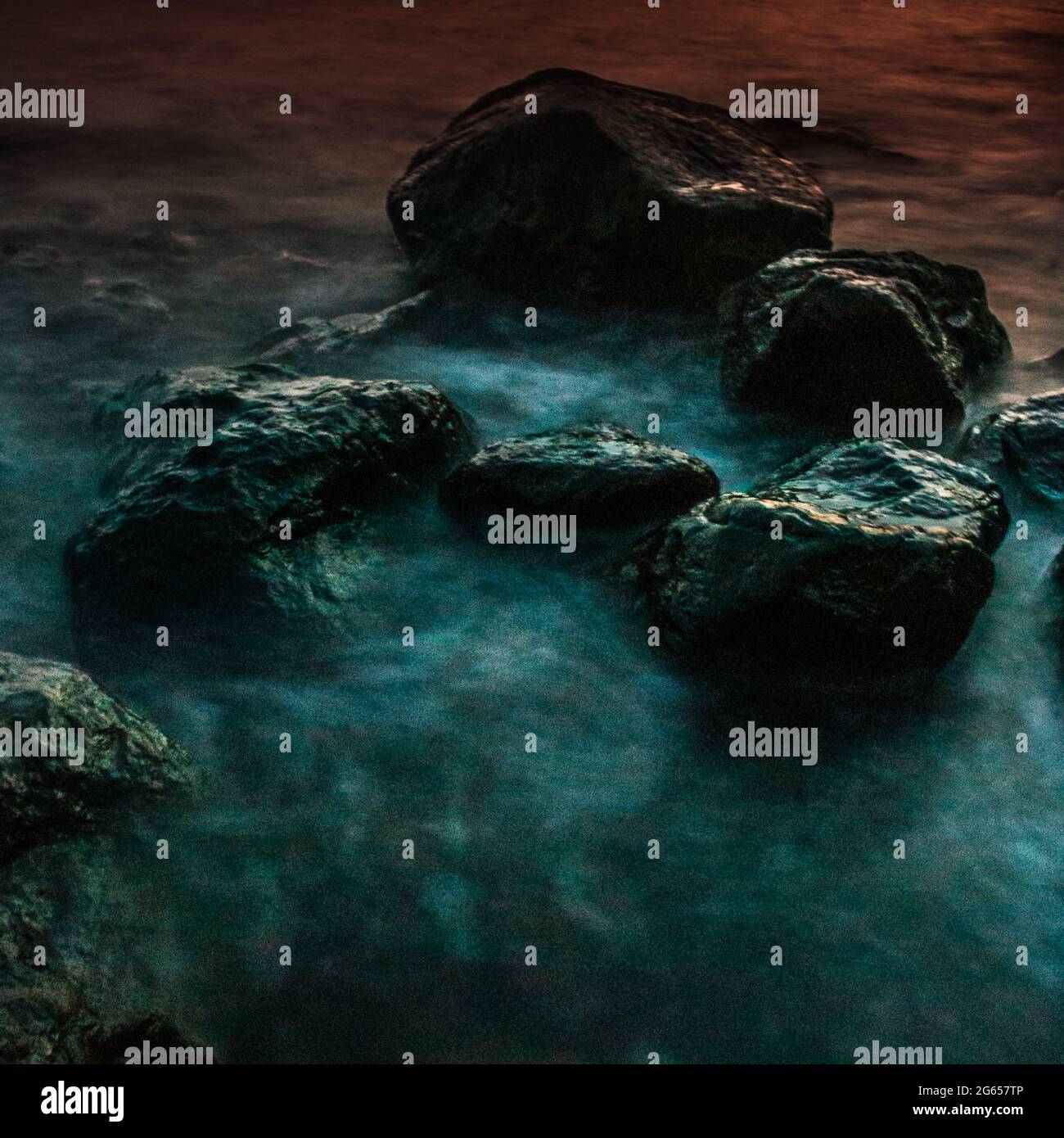 Rocks and flowing waves Stock Photo - Alamy