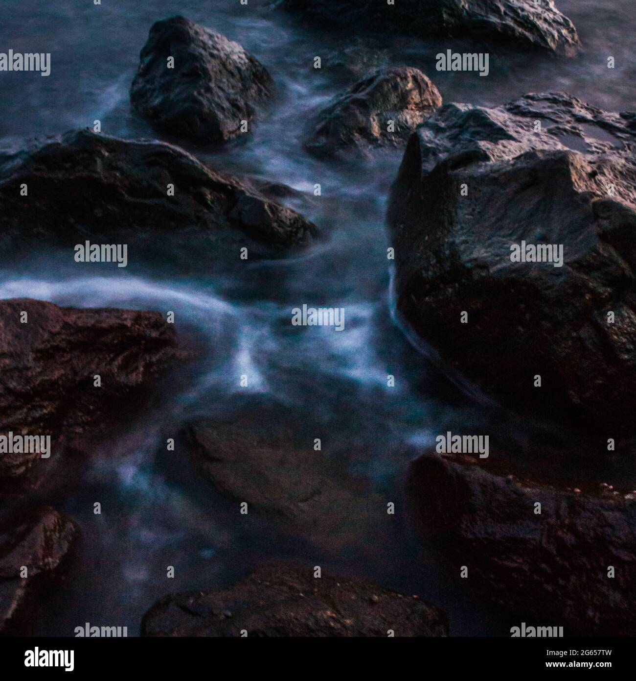 Rocks and flowing waves Stock Photo - Alamy