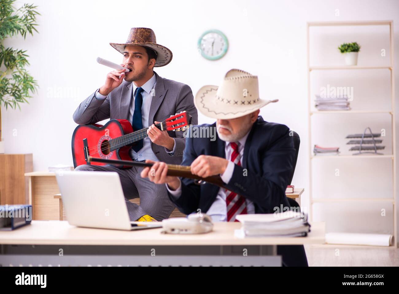Two male cowboy employees during break in the office Stock Photo - Alamy