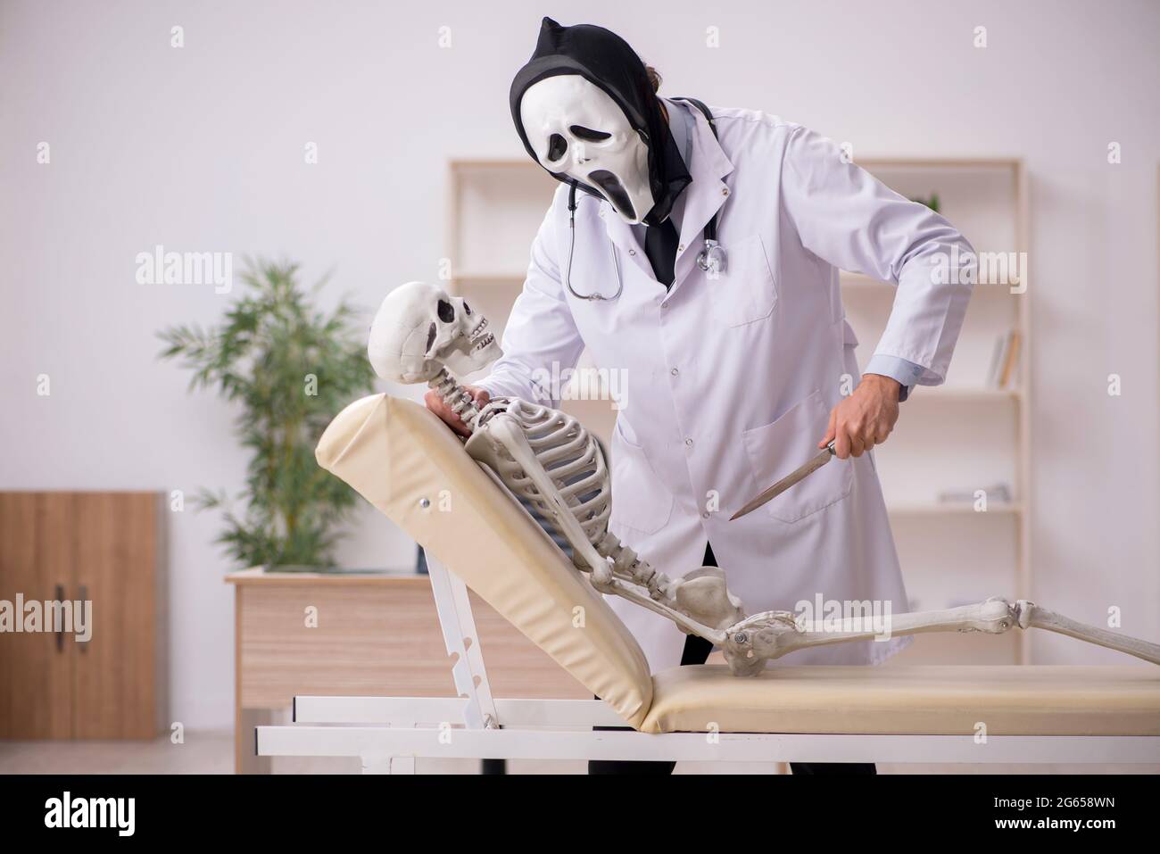 Devil doctor examining skeleton patient in the clinic Stock Photo - Alamy