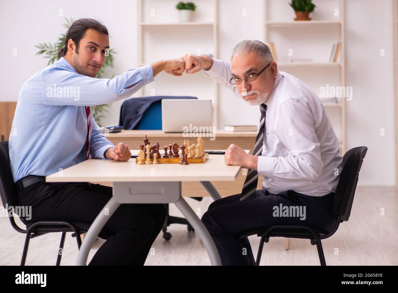 Two male employees playing chess at workplace Stock Photo - Alamy