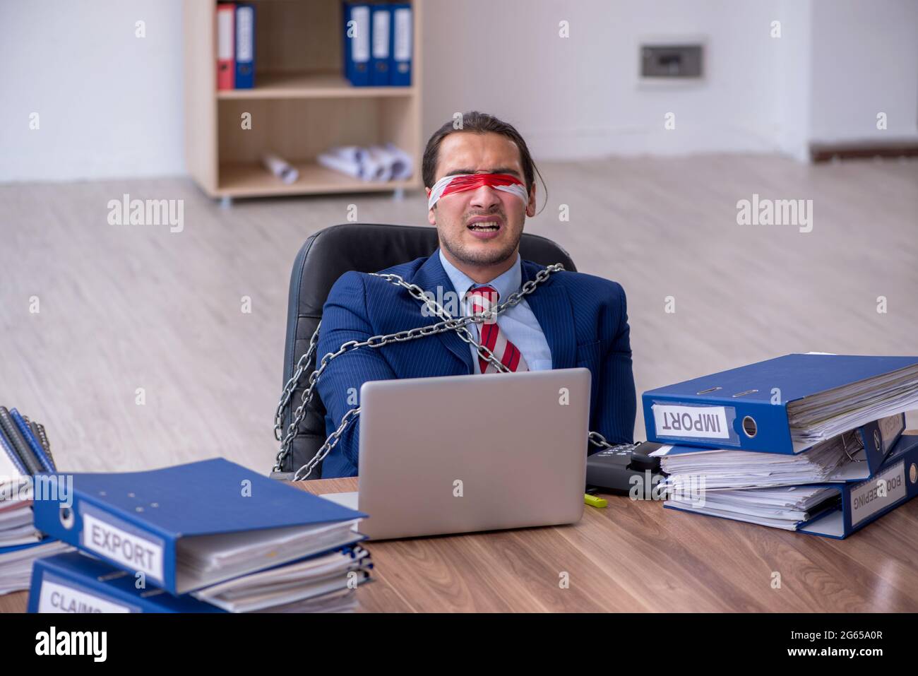 Chained employee unhappy with excessive work in the office Stock Photo ...