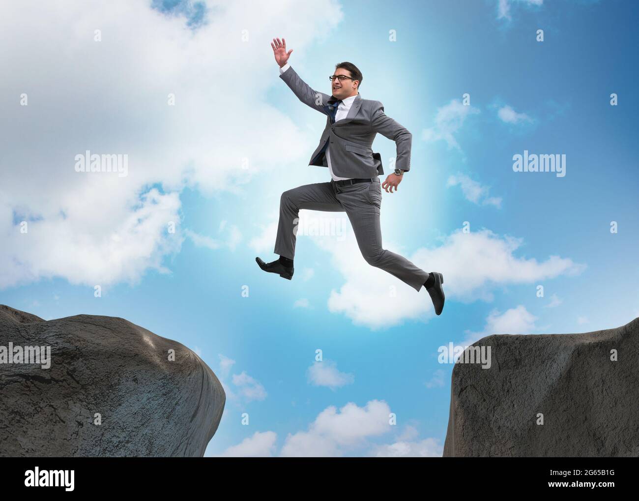 The ambitious businessman jumping over the cliff Stock Photo - Alamy