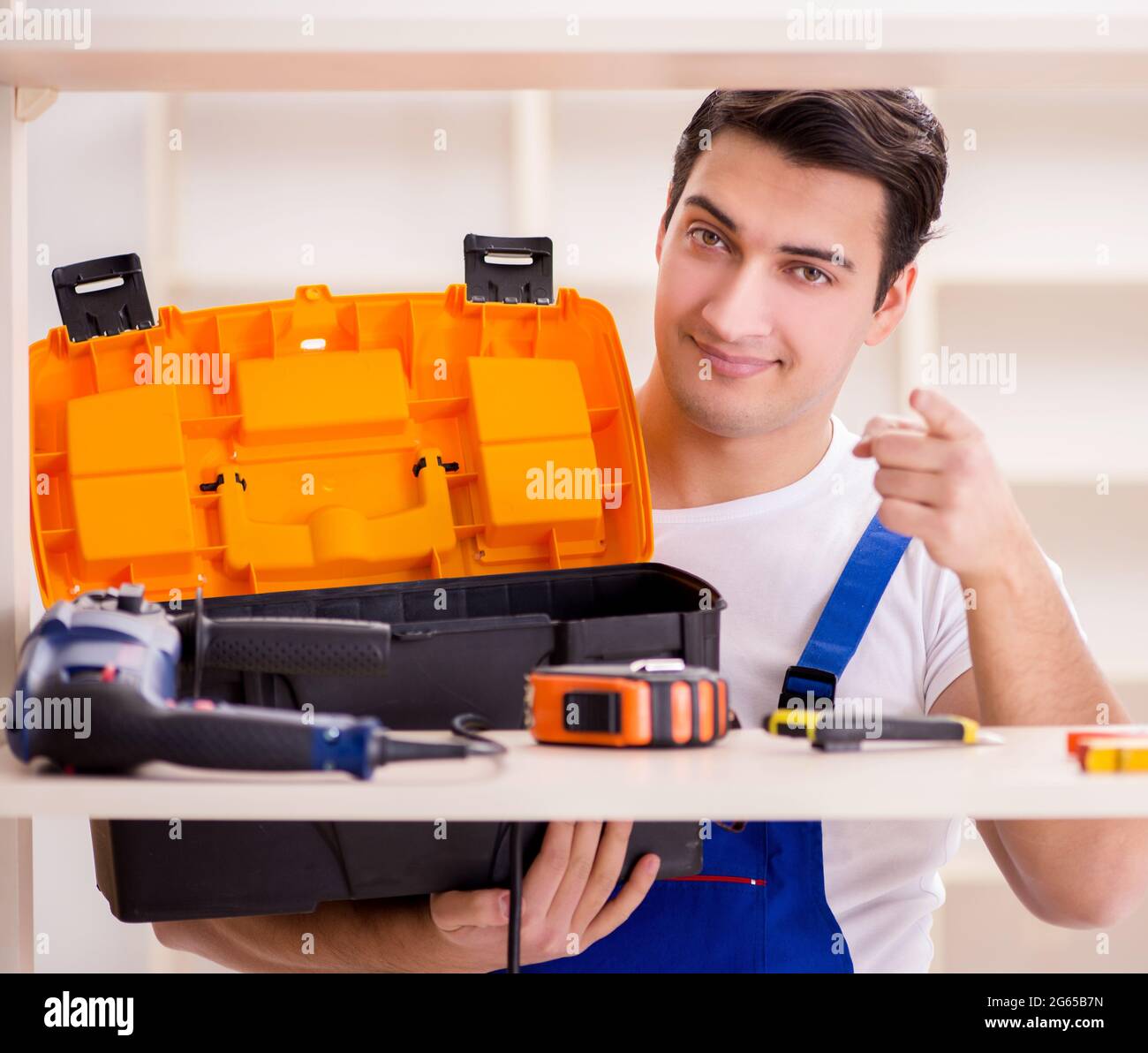 The worker man repairing assembling bookshelf Stock Photo - Alamy