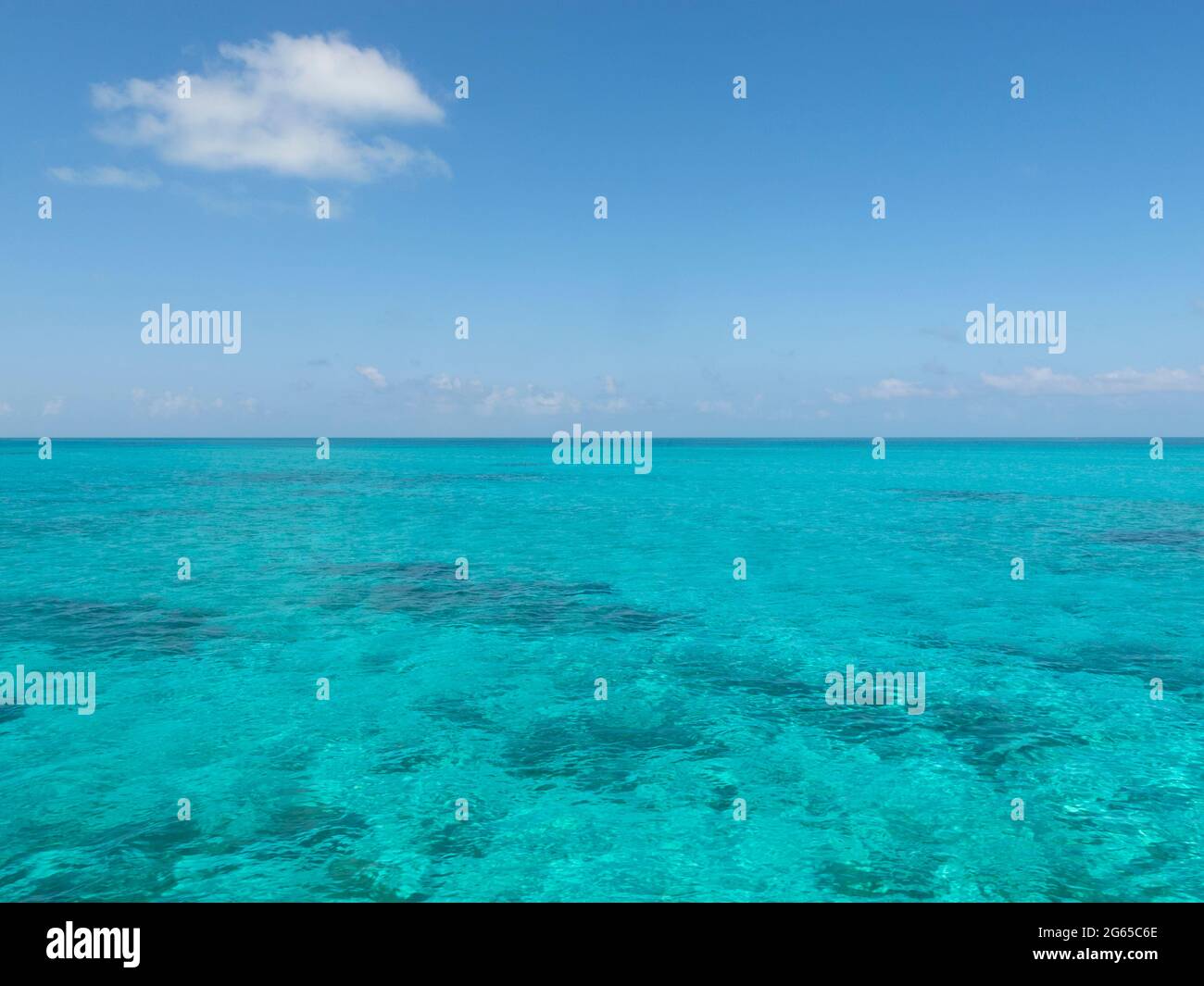 A single cloud hangs over shallow teal water Stock Photo - Alamy