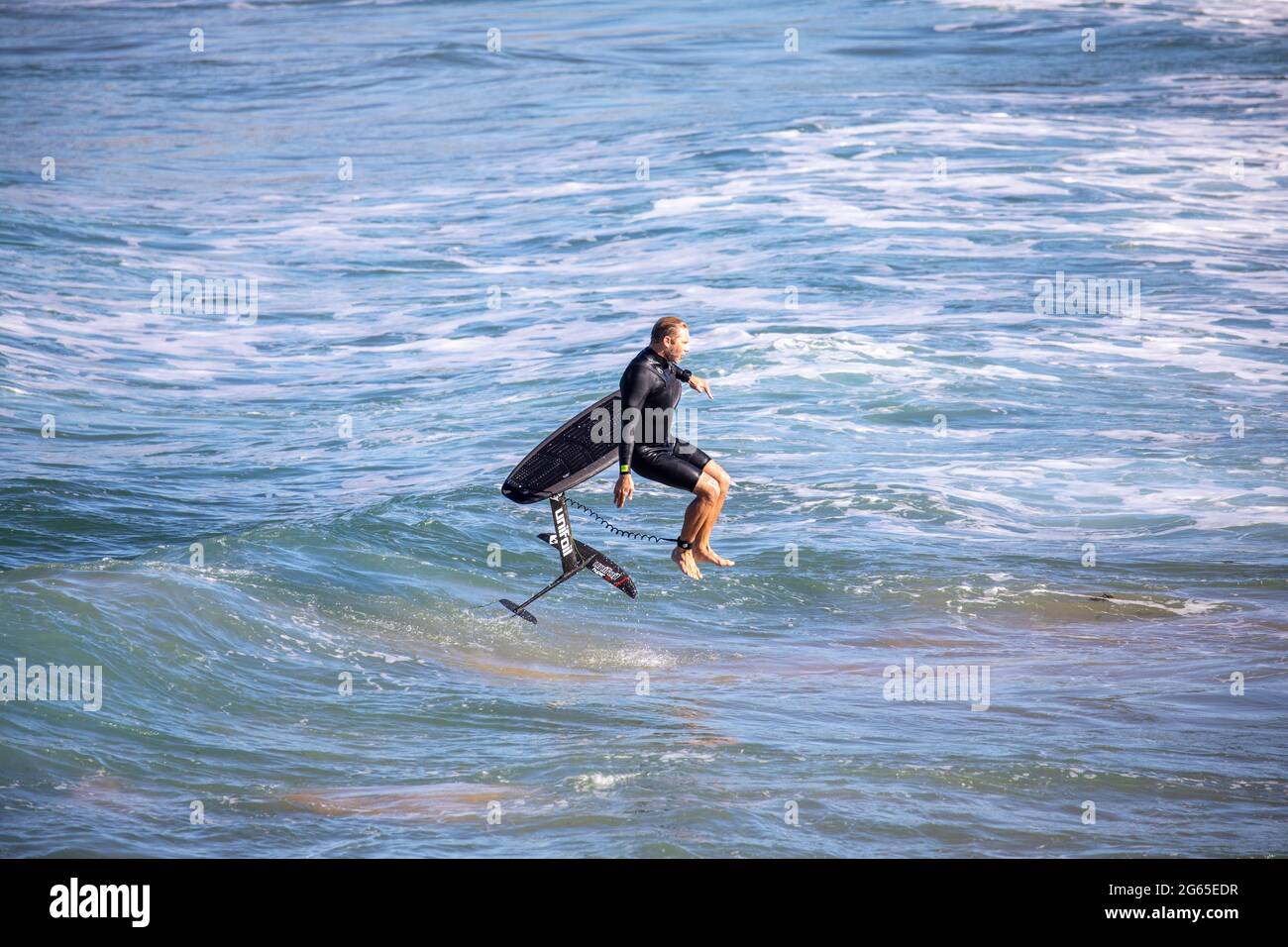 Australian man surfing in Sydney on a hydrofoil trefoil surfing board ...