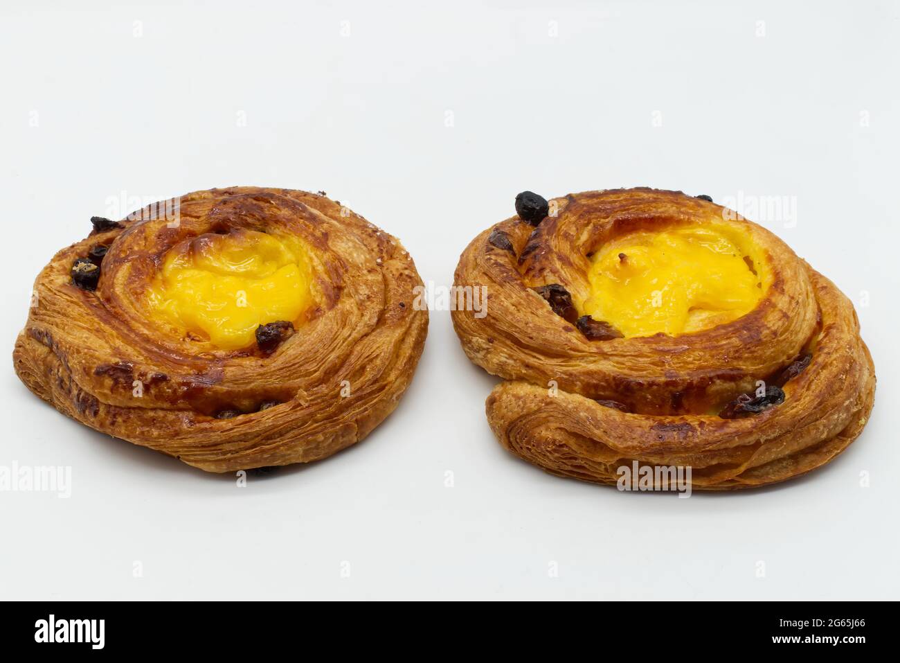 Two raisins cream brioches isolated on white background Stock Photo - Alamy