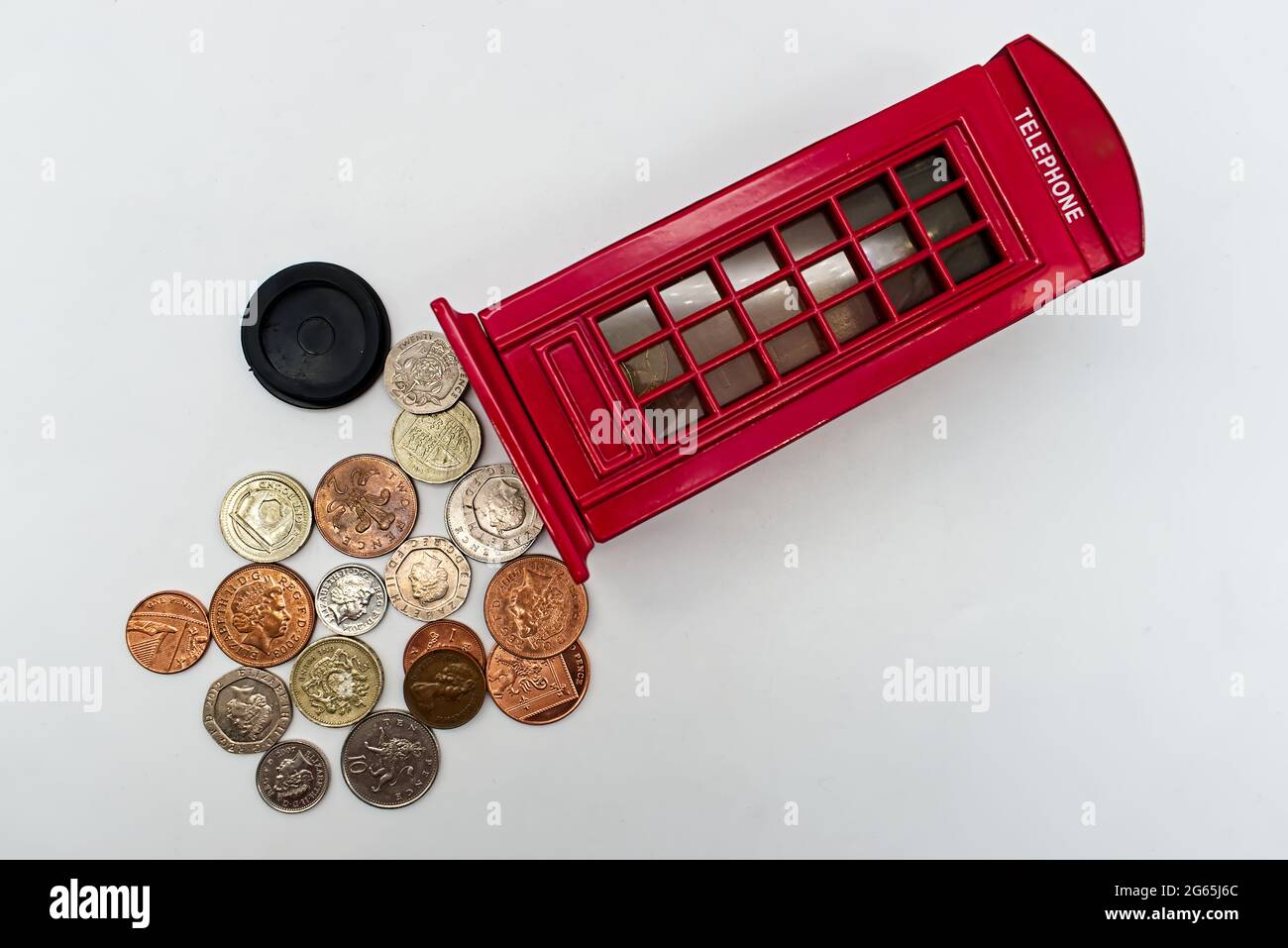 British piggy bank with a group of British coins isolated on white ...