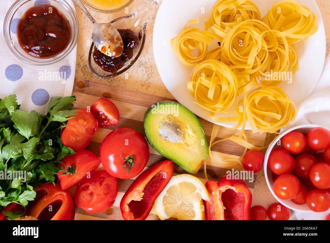 raw tagliatelle and ingredients for cooking pasta on the tables ...