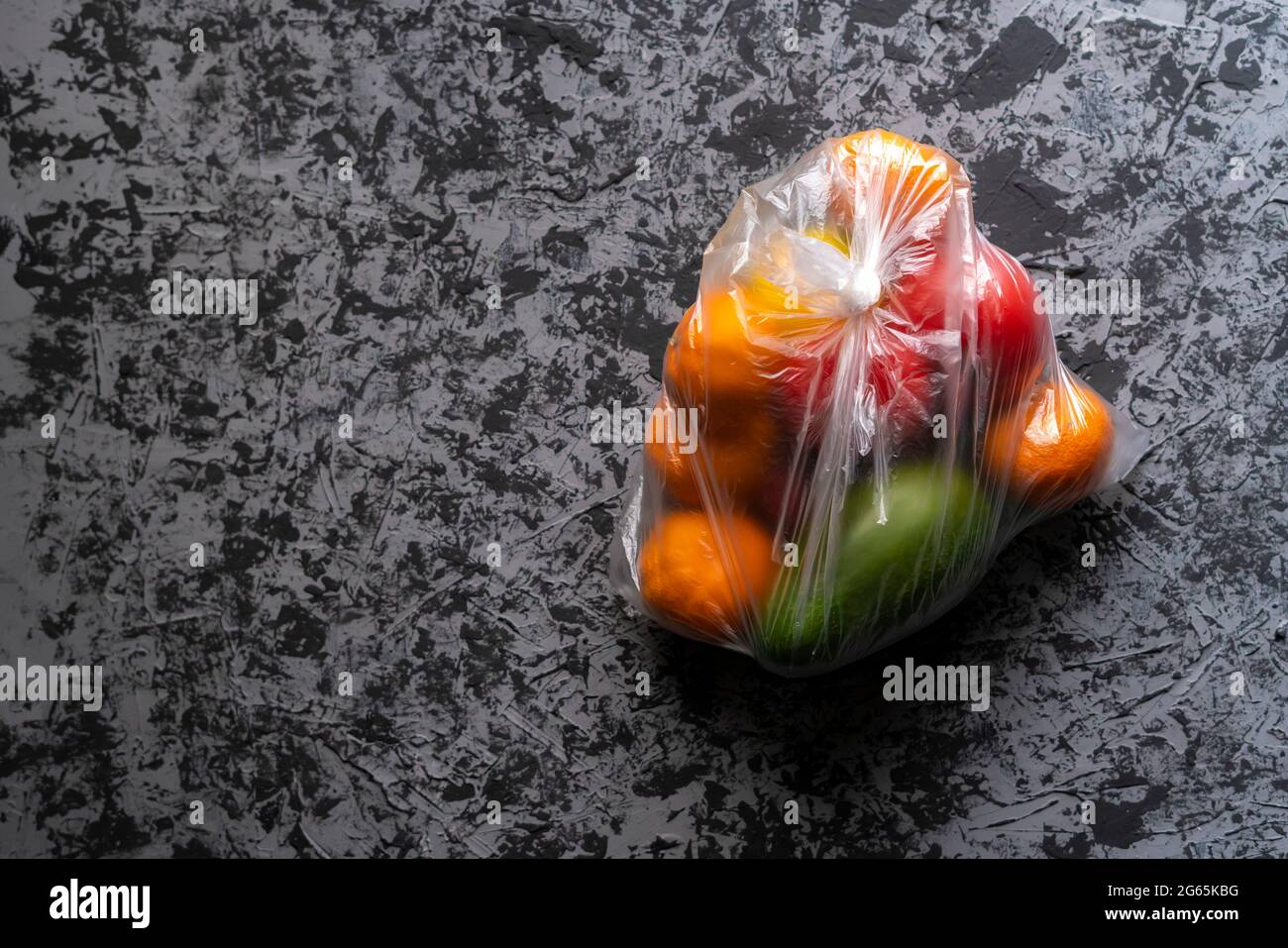 damaged spoiled fruits in a bag in a dark room, plastic container harm ...