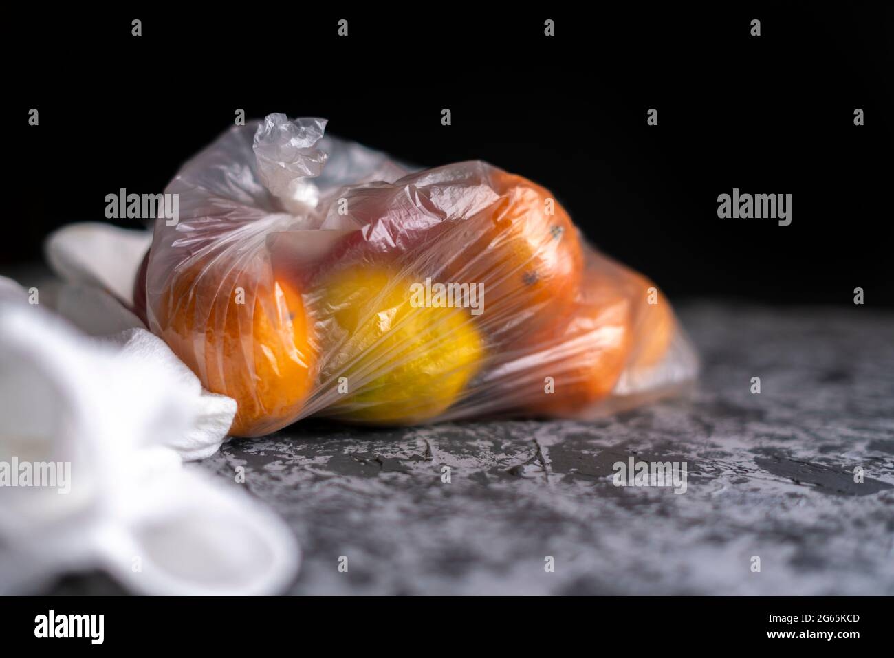 damaged spoiled fruits in a bag in a dark room, plastic container harm ...