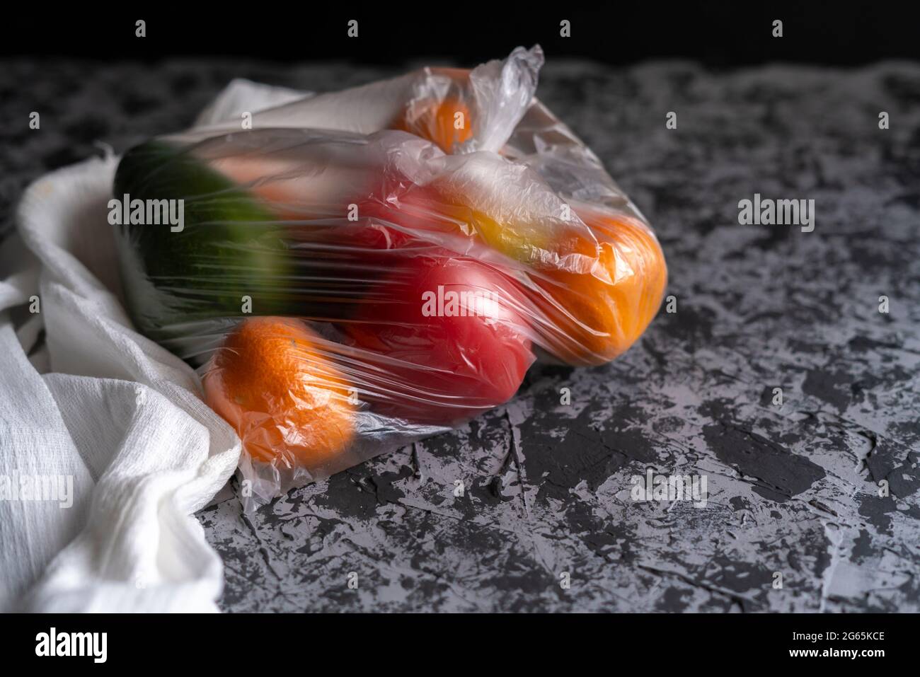 damaged spoiled fruits in a bag in a dark room, plastic container harm ...