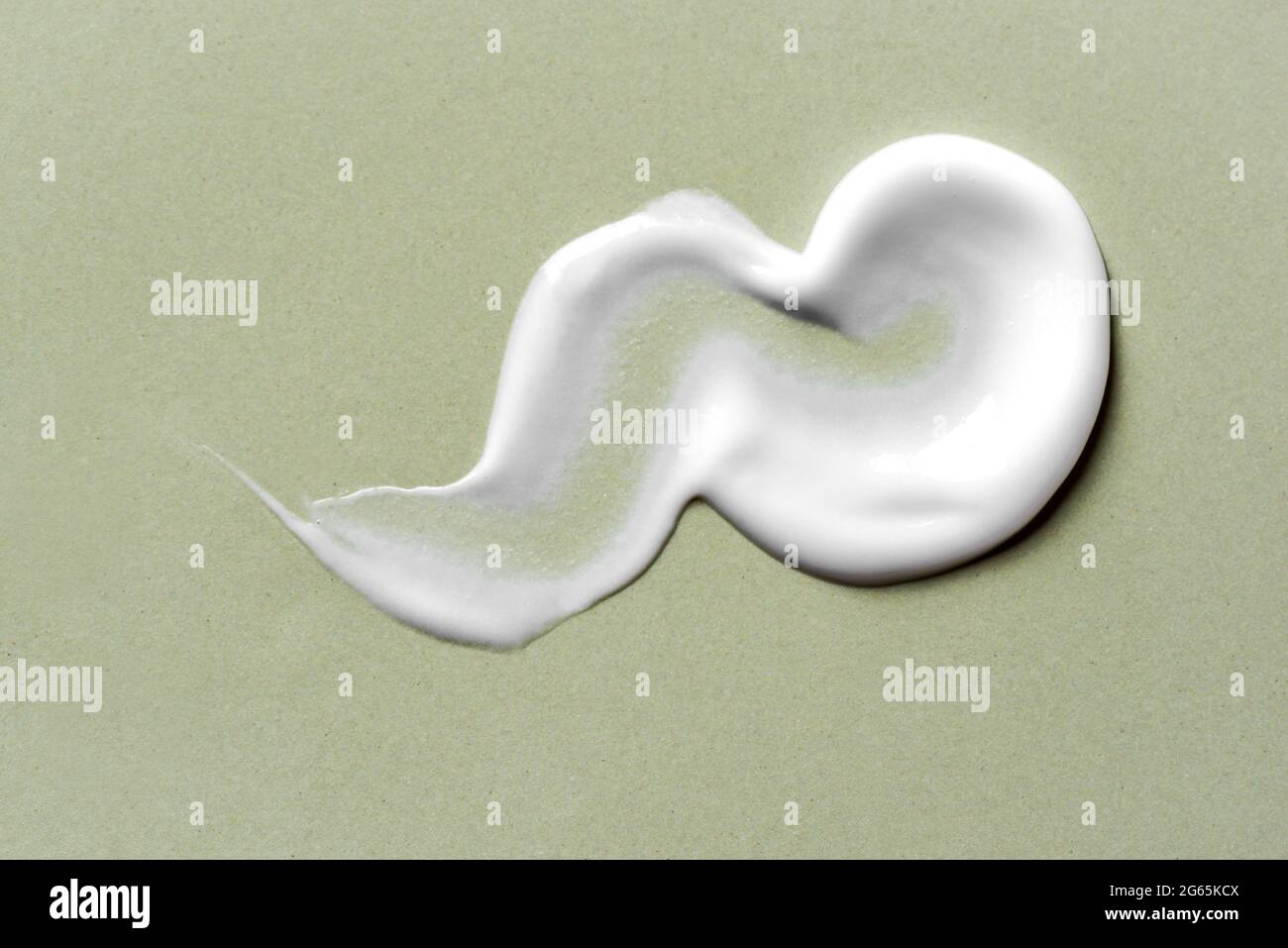 Cosmetic cream drop texture smudged on green background, top view ...